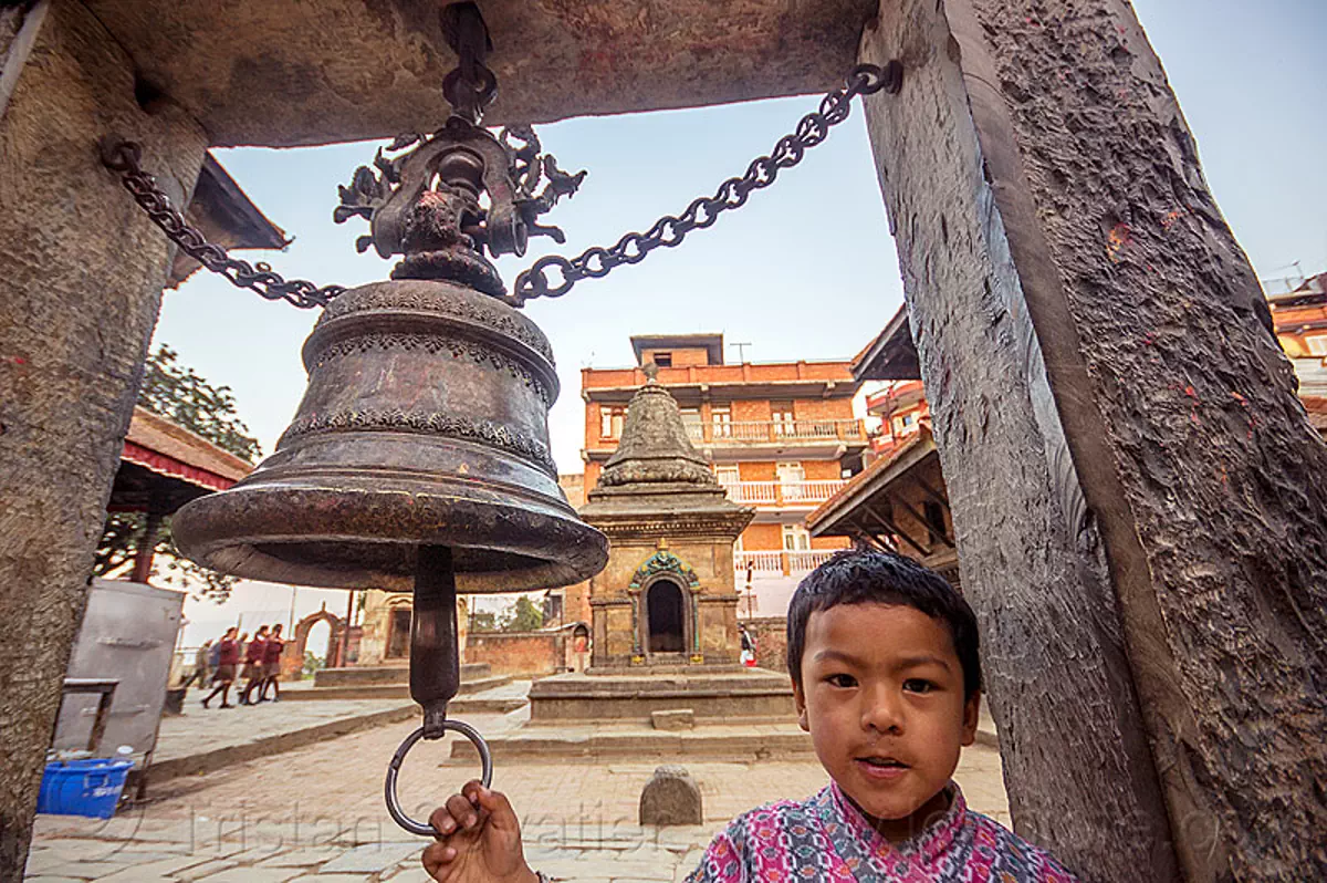 nepali boy ringing temple bell, nepal