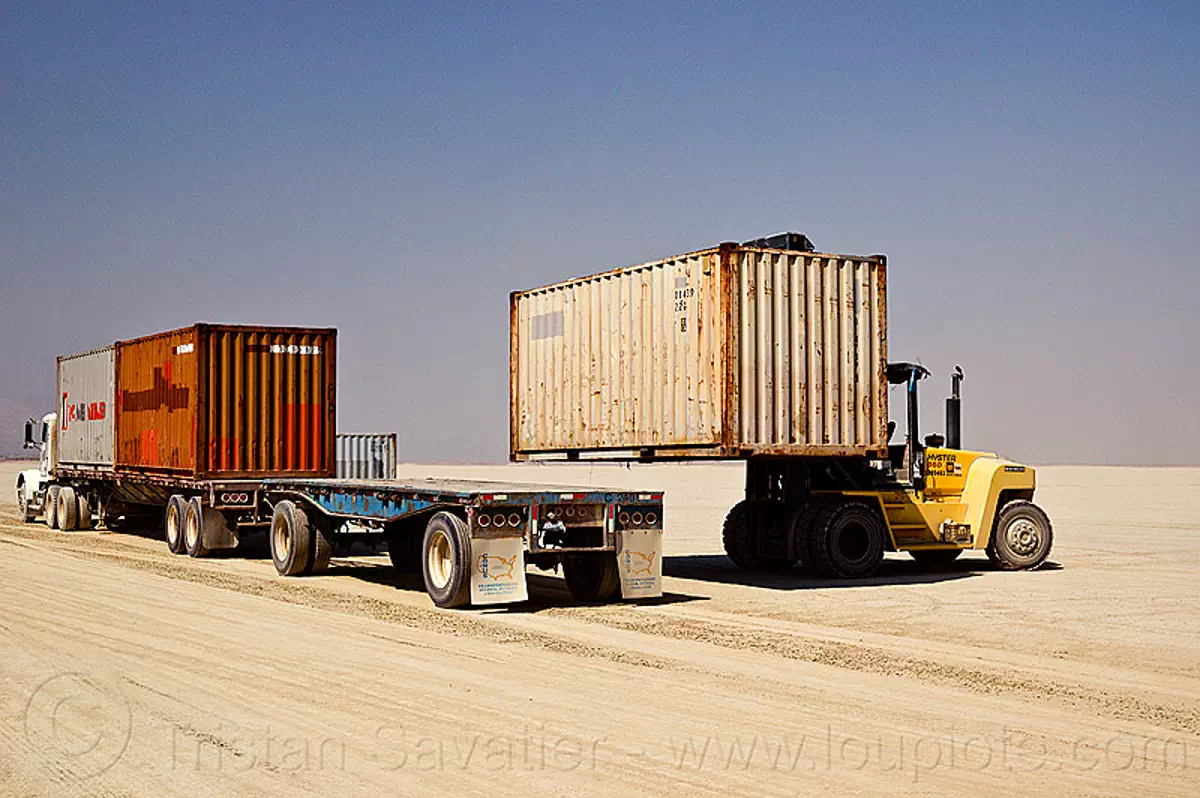 burning man, unloading containers from semi truck trailer