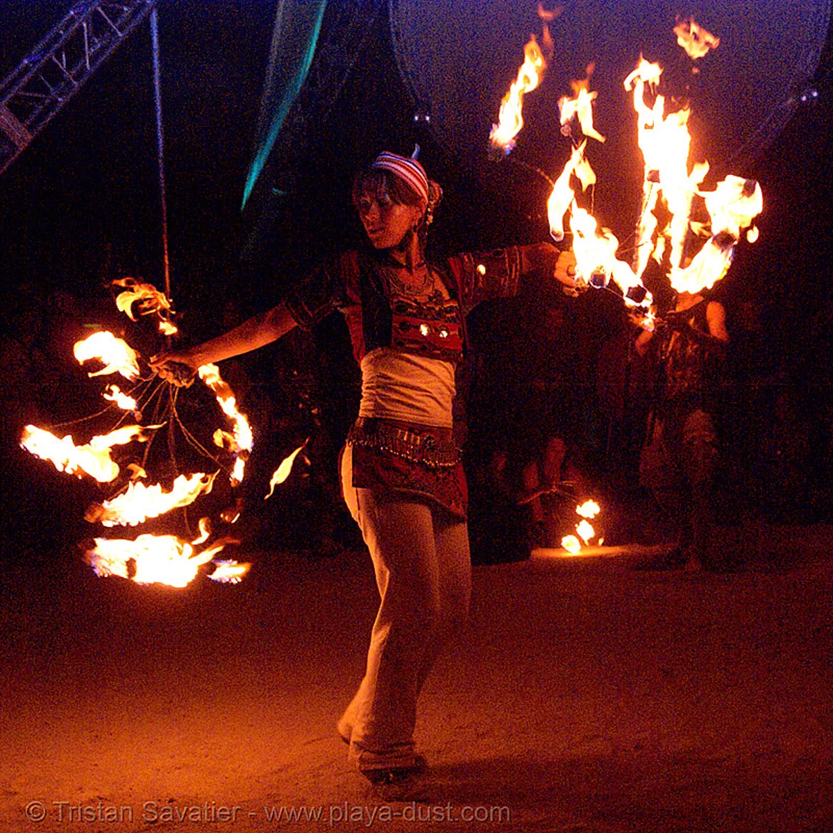 burning man, woman dancing with fire fans
