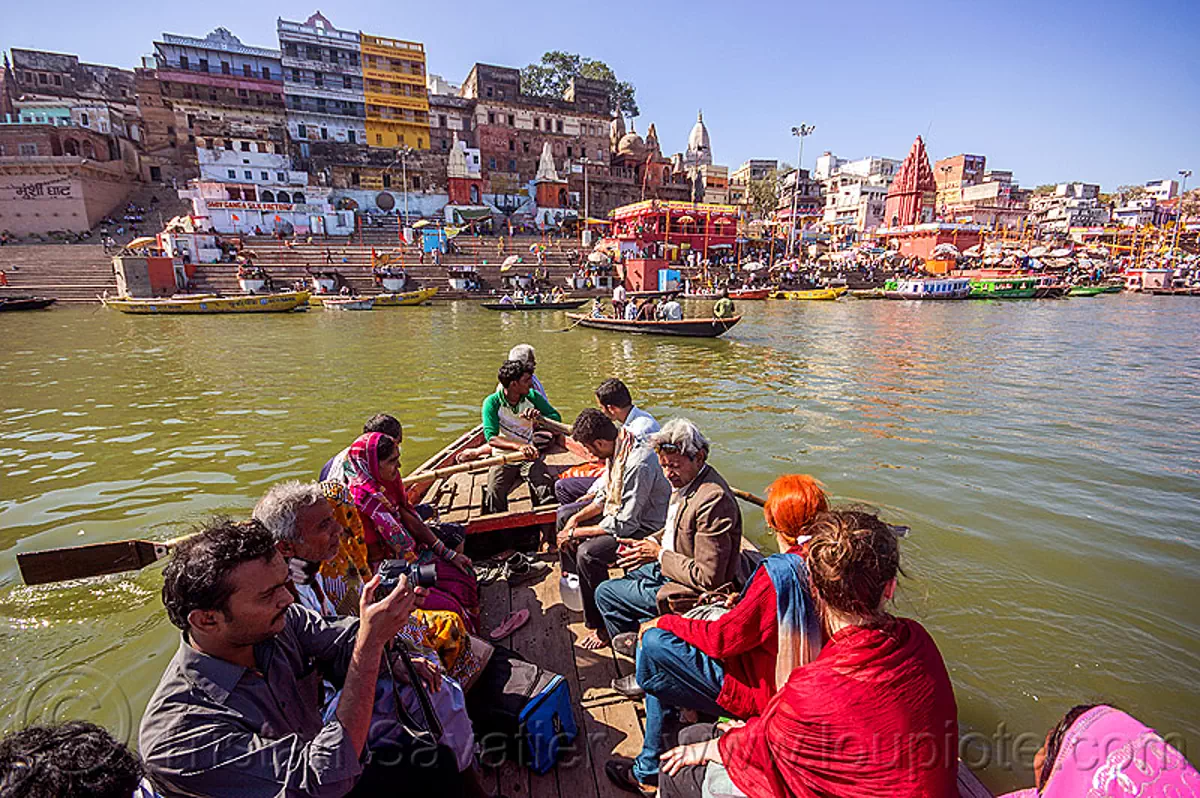 hindu pilgrims on river boat, ghats of varanasi, india