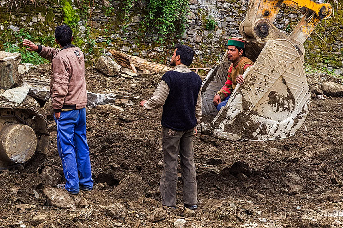 man in excavator bucket, india