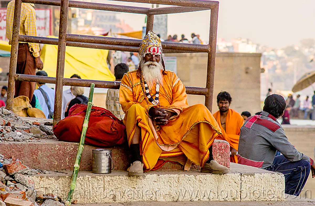 old sadhu sitting on a ghat, varanasi, india