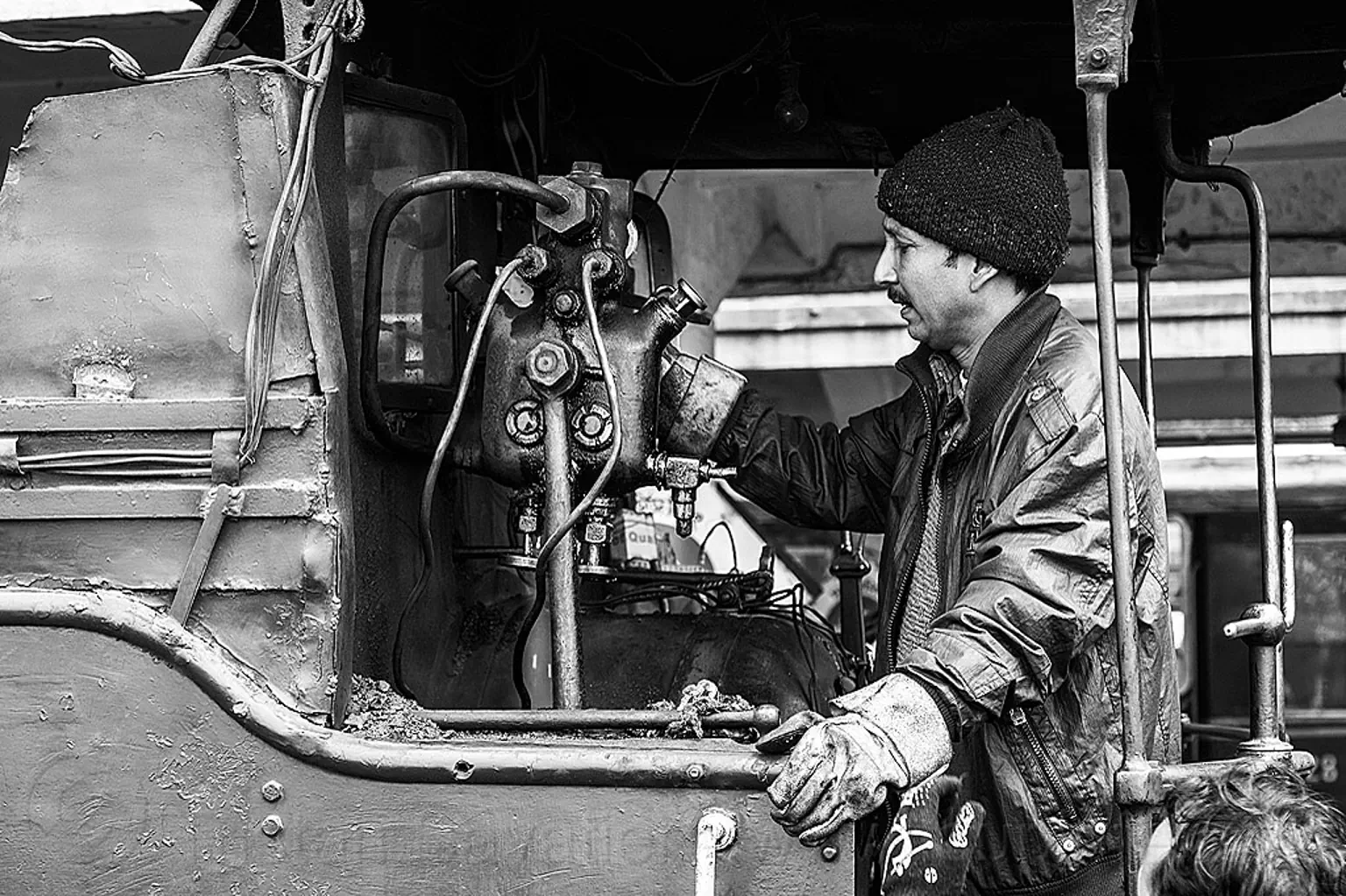 operator at the controls of a steam locomotive, darjeeling, india