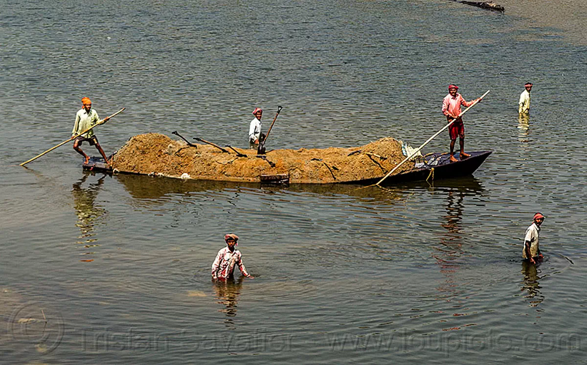 overloaded river boat loaded with sand, india