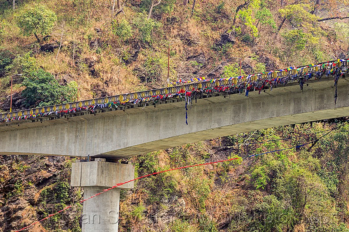 prayer flags on concrete bridge, india