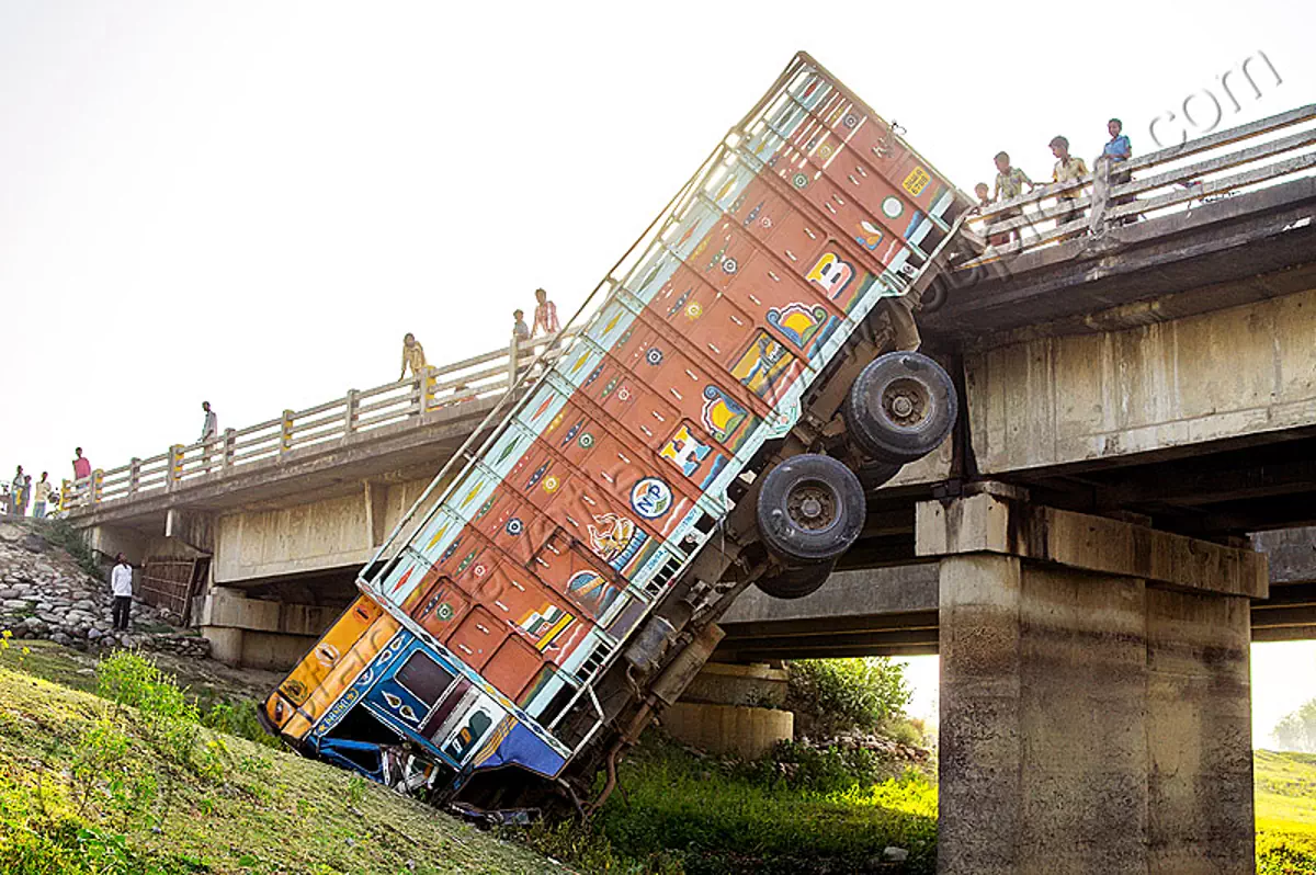 truck hanging off overpass, traffic accident, india