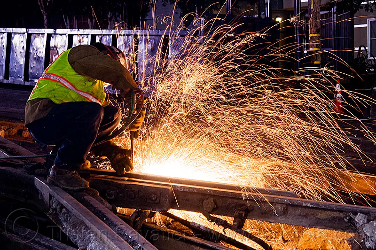 welder using cutting torch to cut a rail